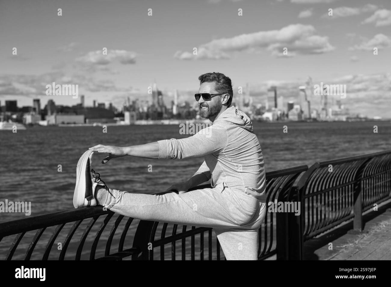 Stretching routine of sportsman in NY. Sportsman stretching his muscles ...