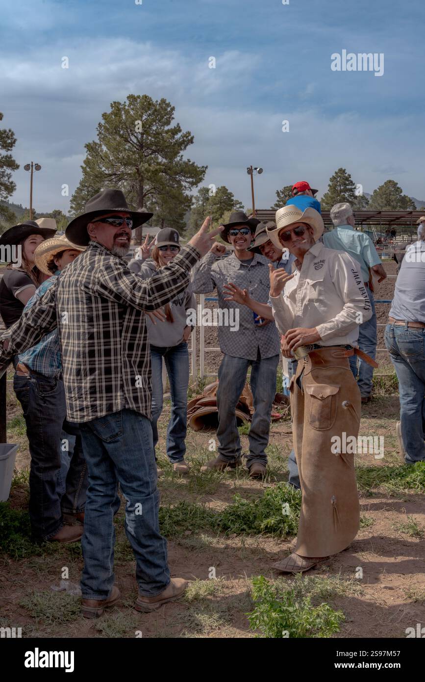 Cowboys and cowgirls look at camera, smile and gesture, at the rodeo in ...