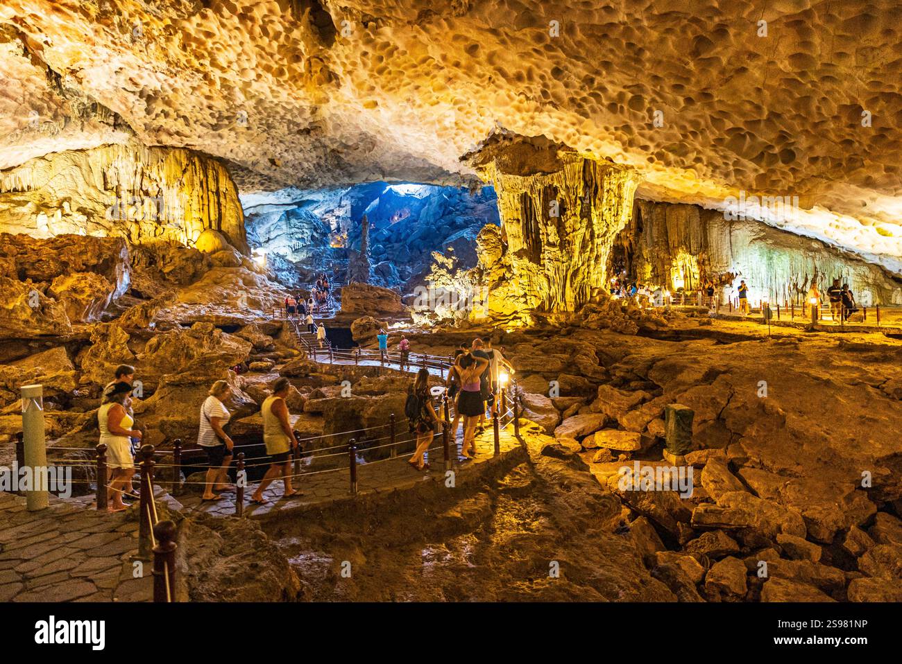 Tourists explore underground cave formations illuminated by colourful lights in Sung Sot Cave ...