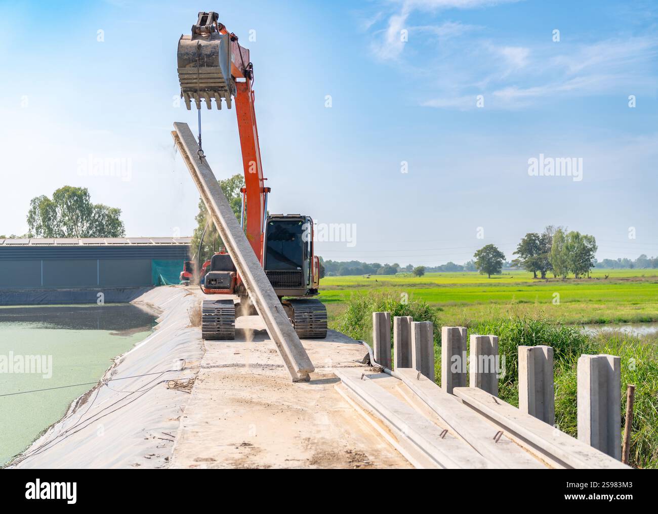 Excavator use bucket arm liftting pile for driving on hole Stock Photo ...