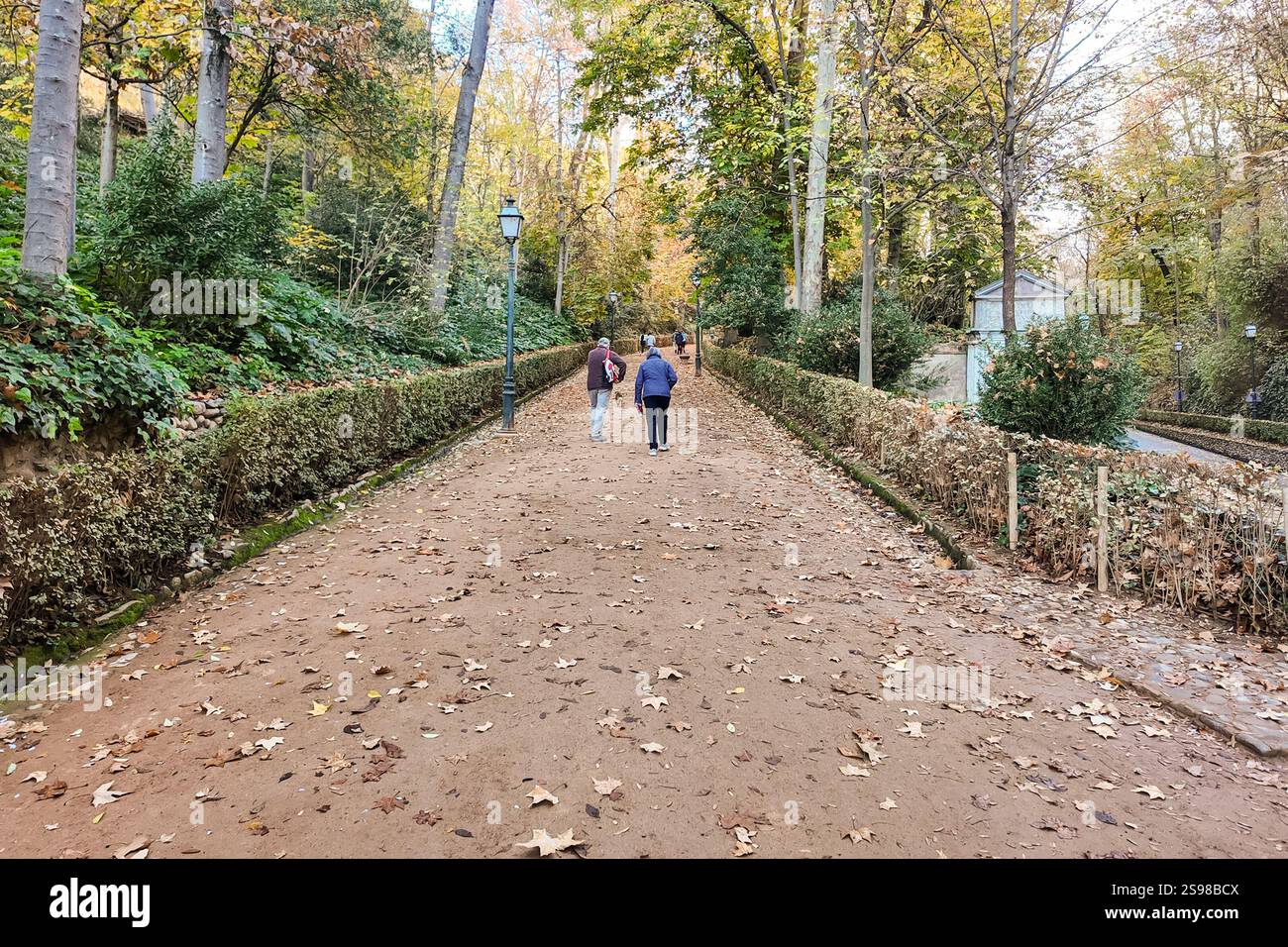 Sign to Alhambra complex along a long steep path, with greenery on ...