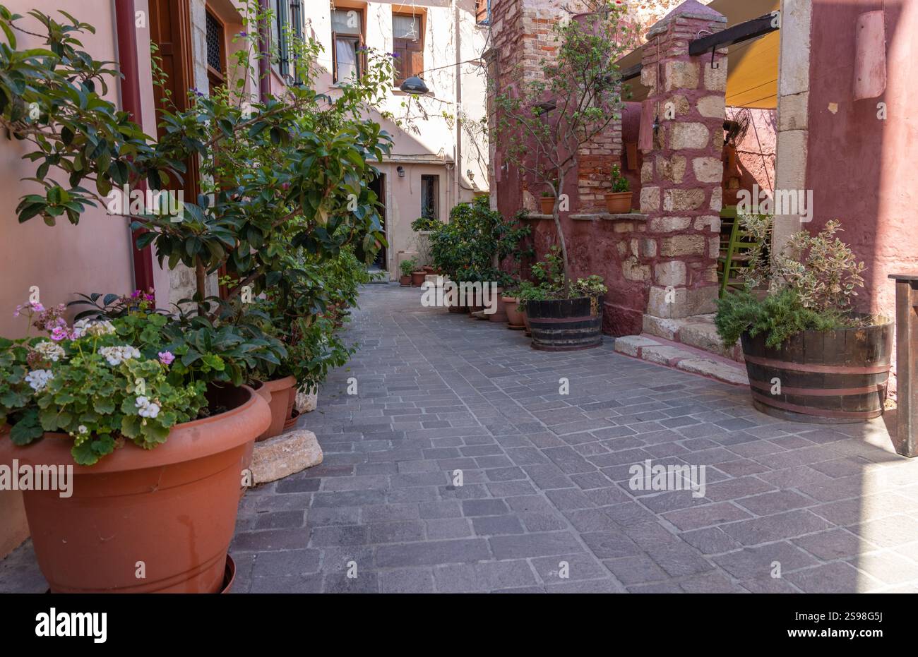 Cobblestone path leading between buildings typically Greek with walls ...