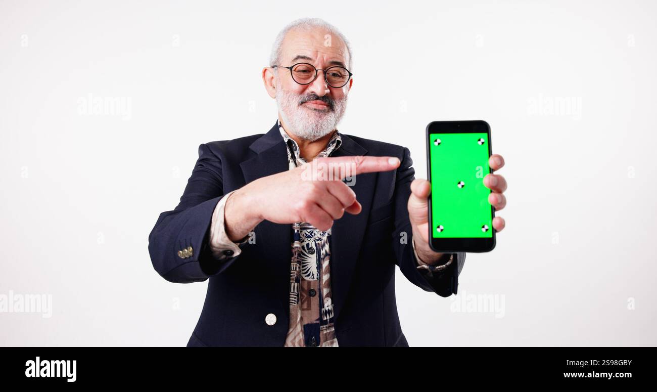 Studio, green screen and mature man with smartphone, space or pointing ...
