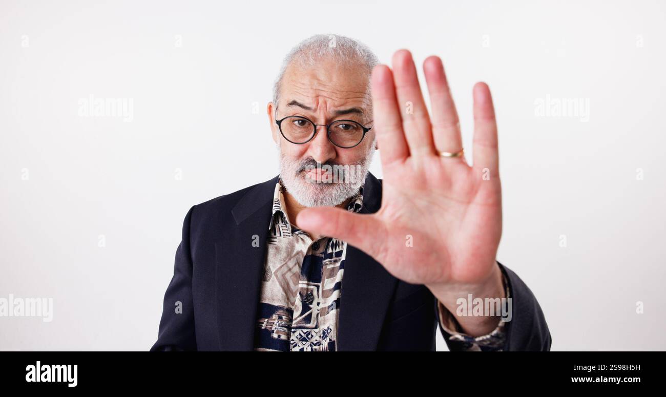 Portrait, senior man and hand gesture for stop in studio of conflict ...