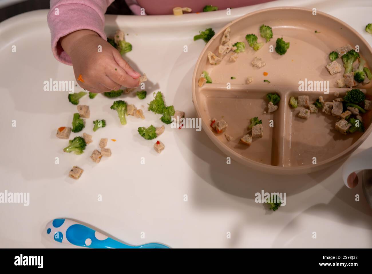 Toddler eating dinner messily Stock Photo - Alamy