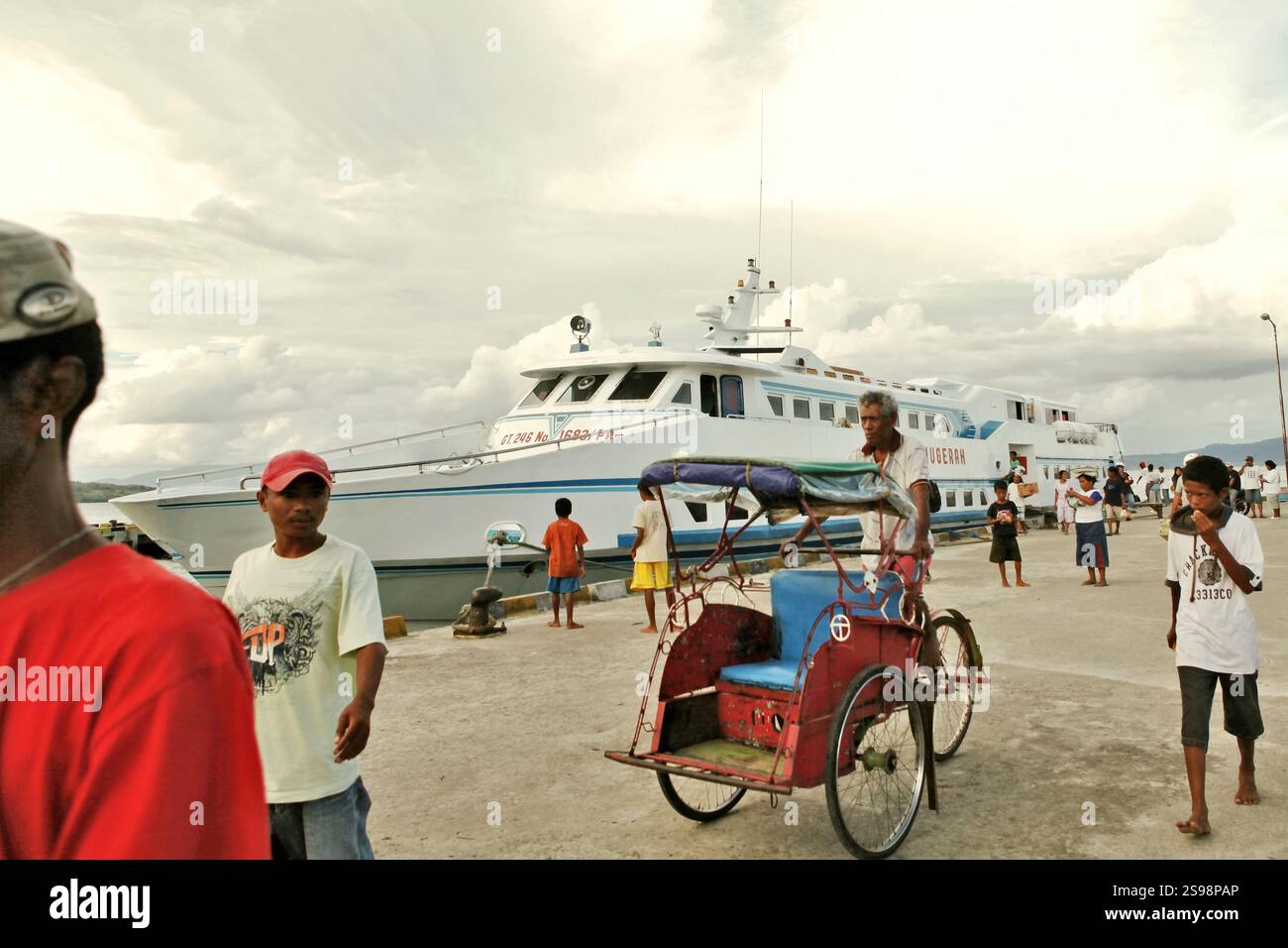 A driver of becak (pedal rickshaw) looking for passengers at the ferry ...