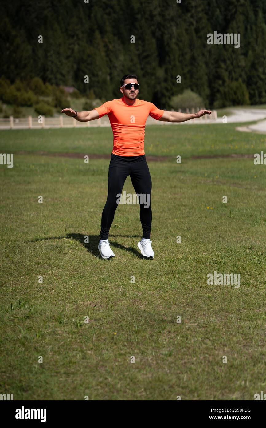 Man Practicing Dynamic Warm-Up Movements On Grass In Nature Stock Photo ...