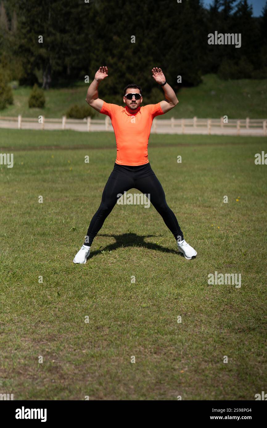 Man Practicing Dynamic Warm-Up Movements On Grass In Nature Stock Photo ...