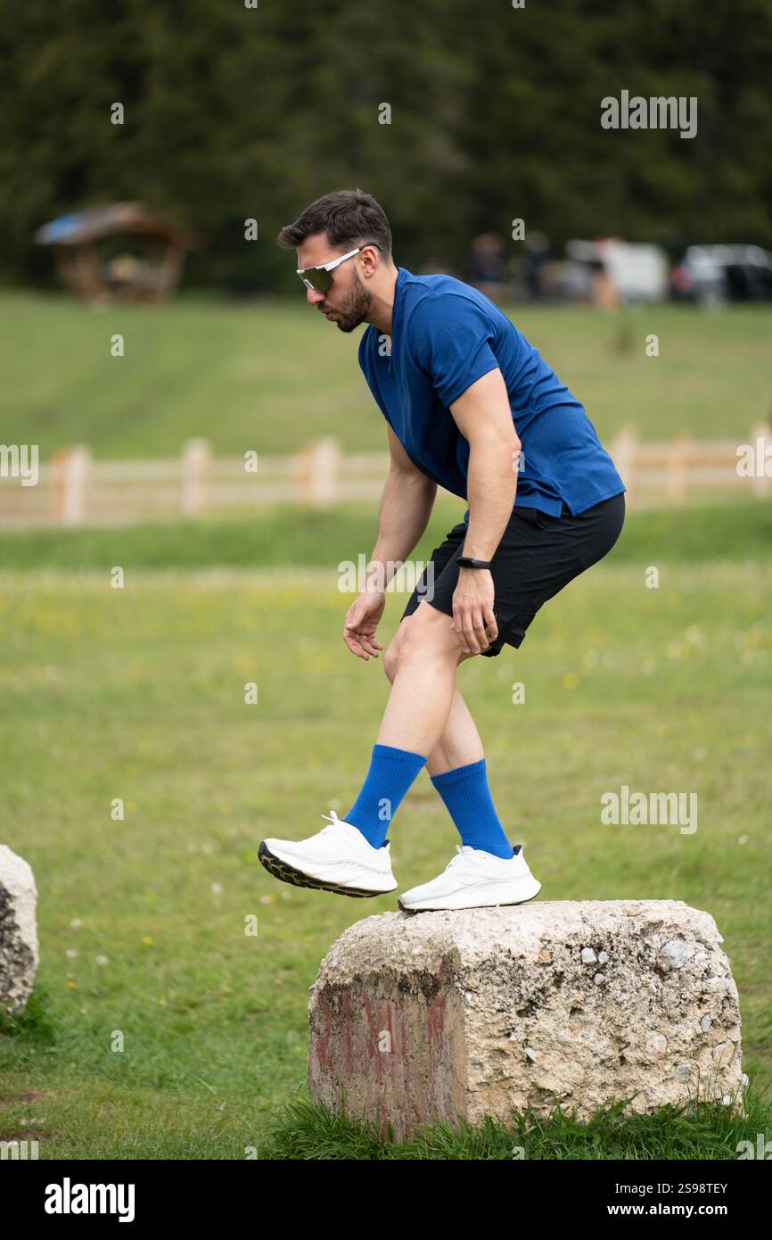 Outdoor Fitness Enthusiast Training On A Rock, Performing A Single-Leg ...