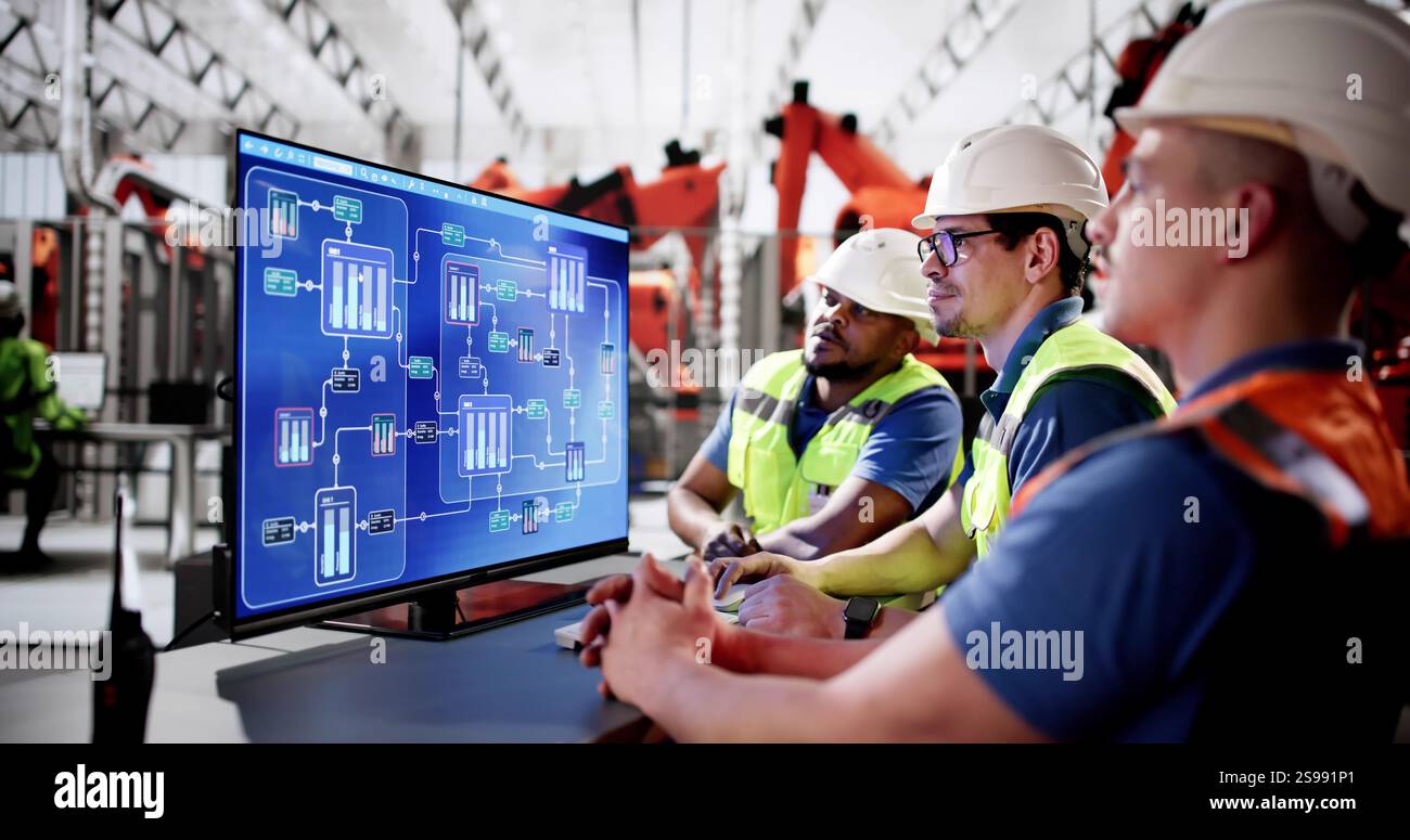 Engineer using Scada desktop software controlling robots at car plant ...