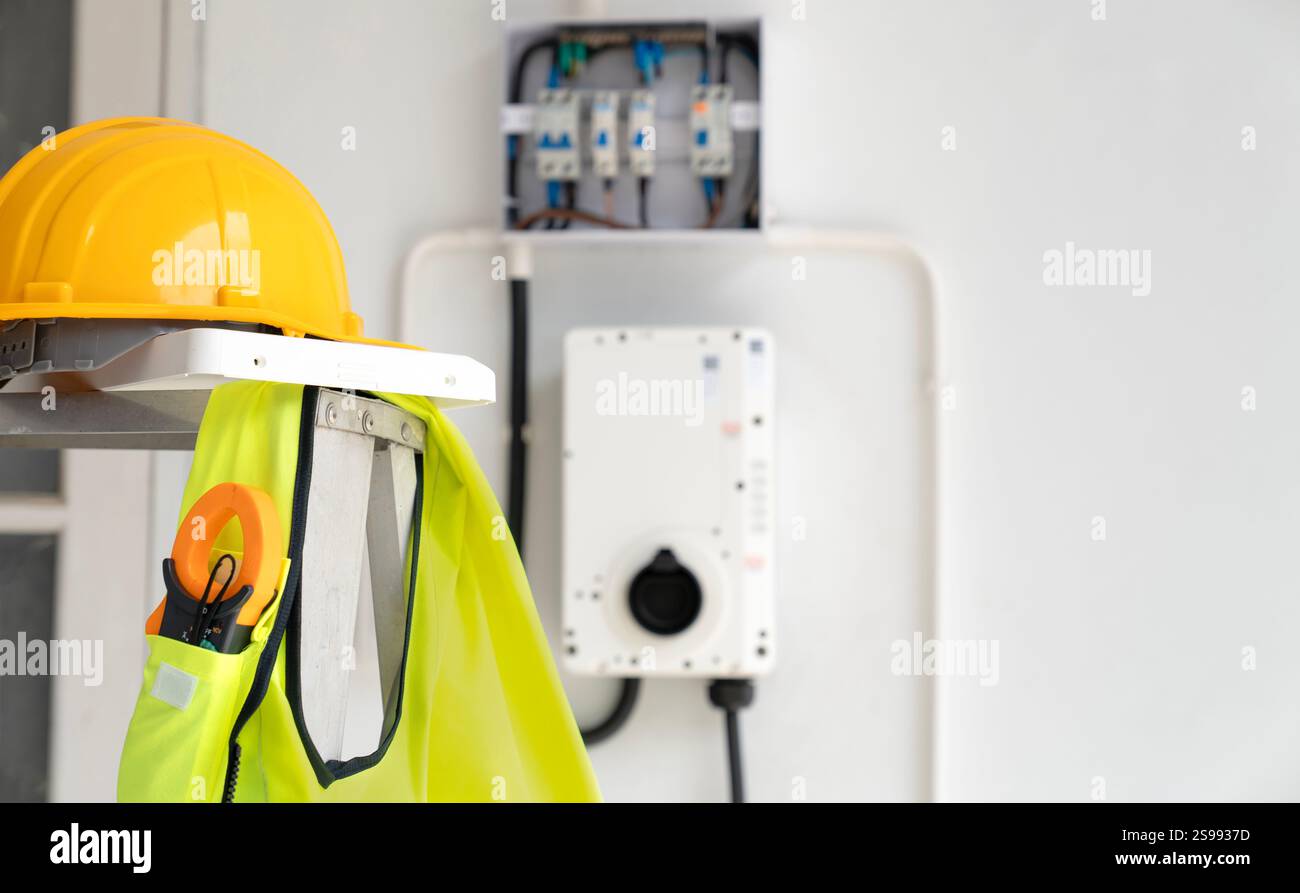 Electrician tools, including a yellow helmet, safety vest, and clamp ...