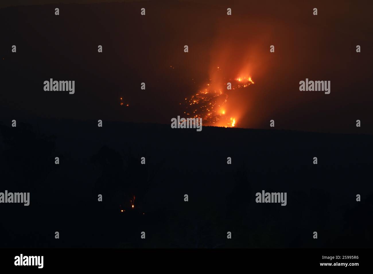 The wildfire is visible burning on the mountain and can be seen from ...