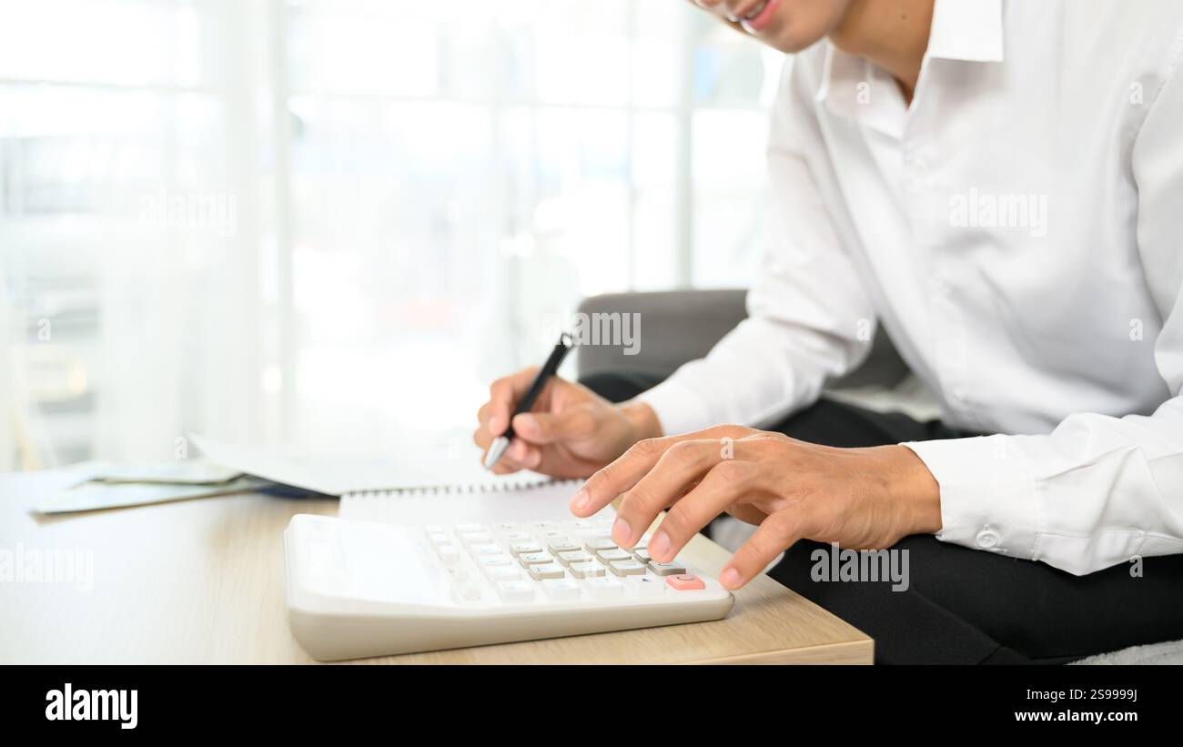 Adult man calculating expenses with calculator to planing budgets. Home ...