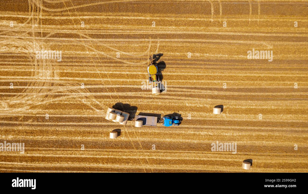 Above top view on excavator as loading straw bales on trailer, tow by ...