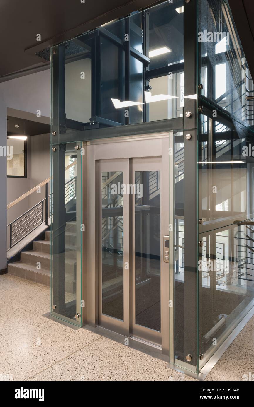 Modern Glass Elevator with Adjacent Staircase Stock Photo - Alamy
