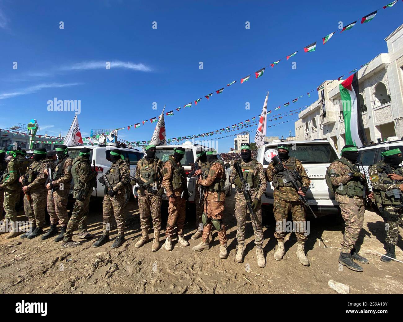Hamas fighters secure an area in a square before handing over four ...