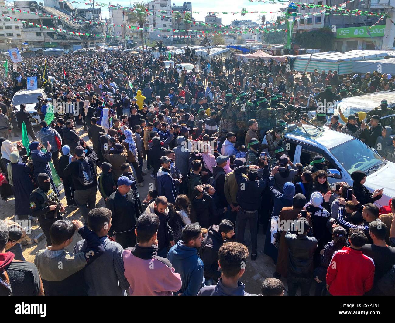 Hamas fighters secure an area in a square before handing over four ...