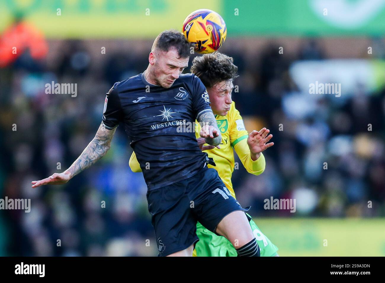 Josh Tymon of Swansea City AFC jumps for the ball with Oscar Schwartau ...