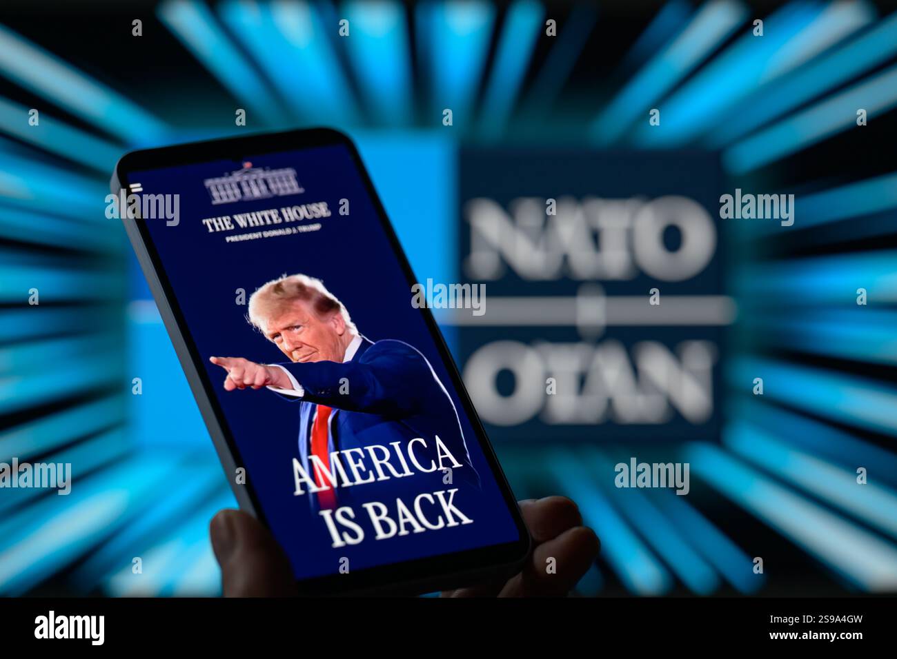 The White House website is displayed on a mobile phone with NATO - OTAN ...