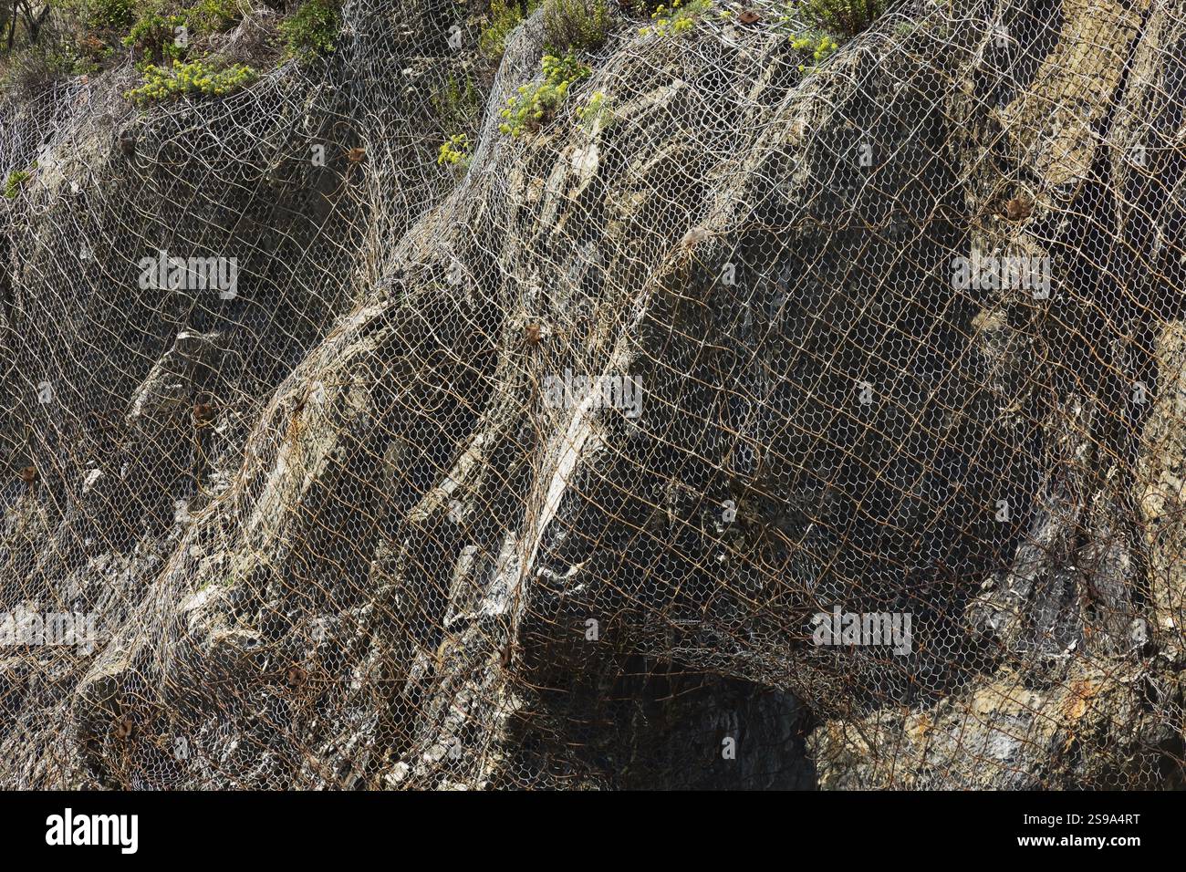 Dangerous rocky cliff protected with steel wire mesh netting to avoid ...
