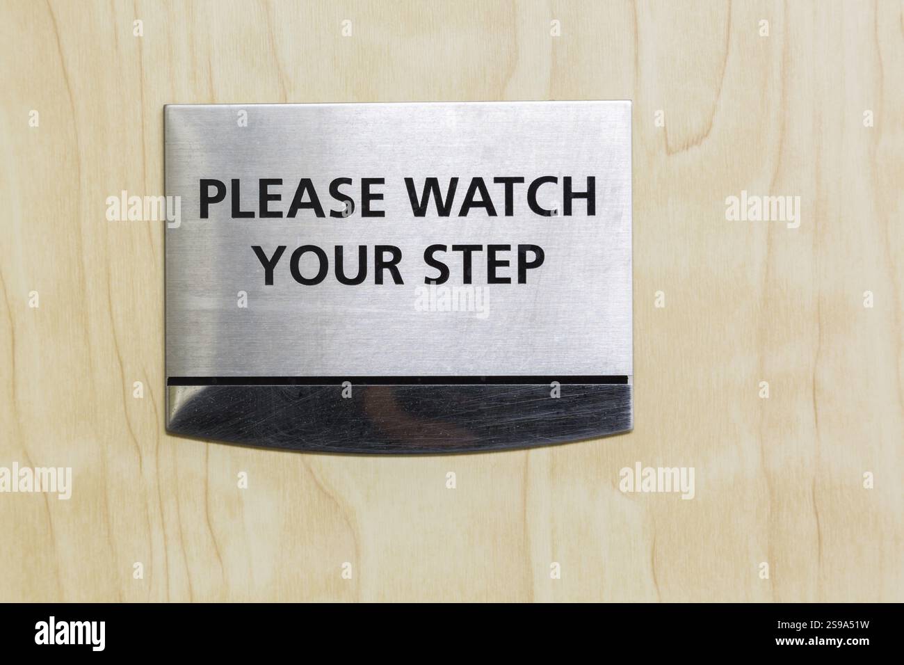 Close-up of engraved black lettering Please Watch Your Step warning ...