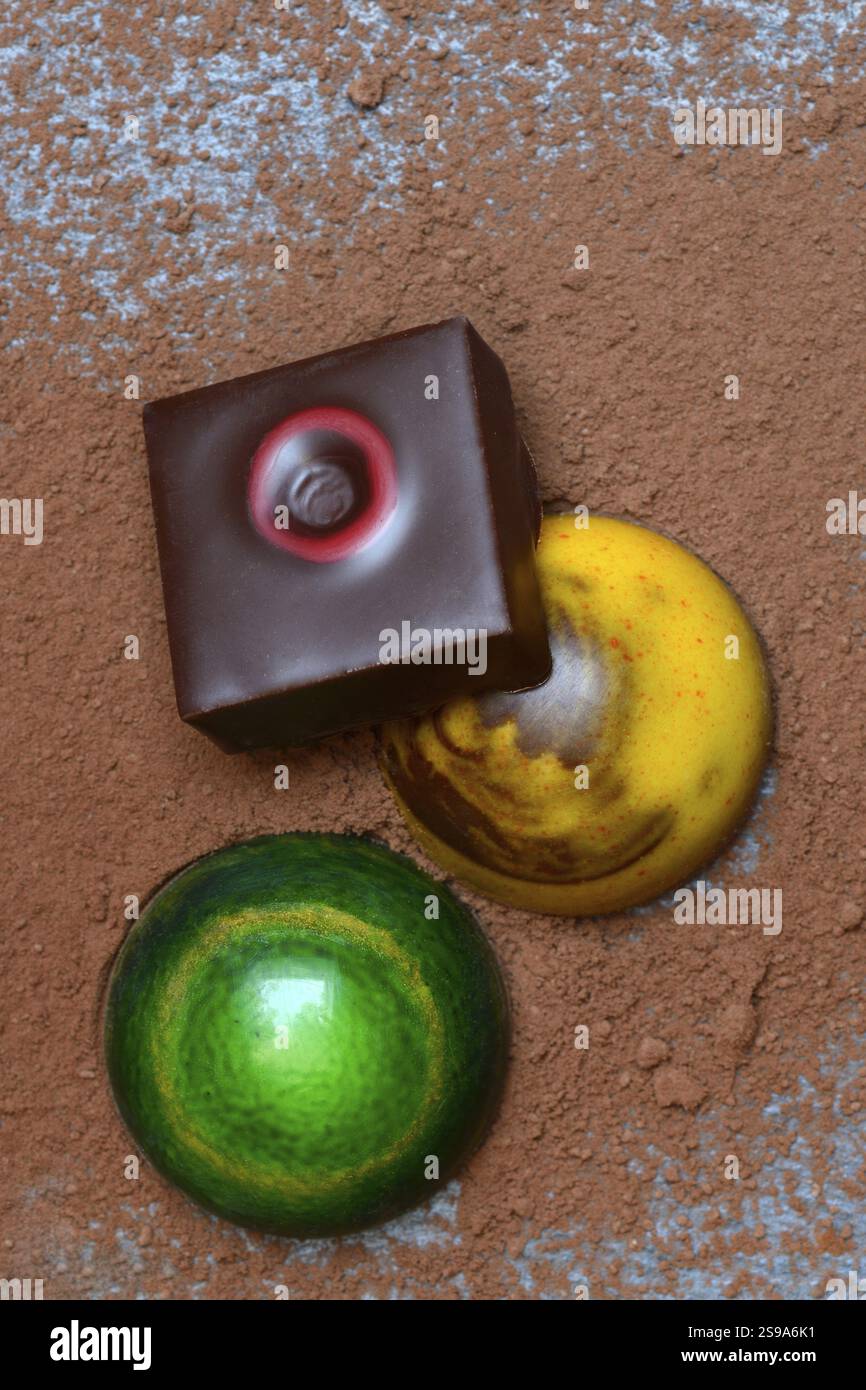 Colourful chocolates on cocoa powder Stock Photo - Alamy