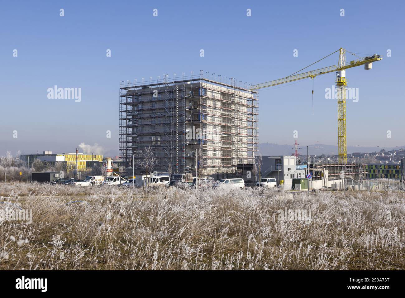 Large building under construction with crane, surrounded by frost ...