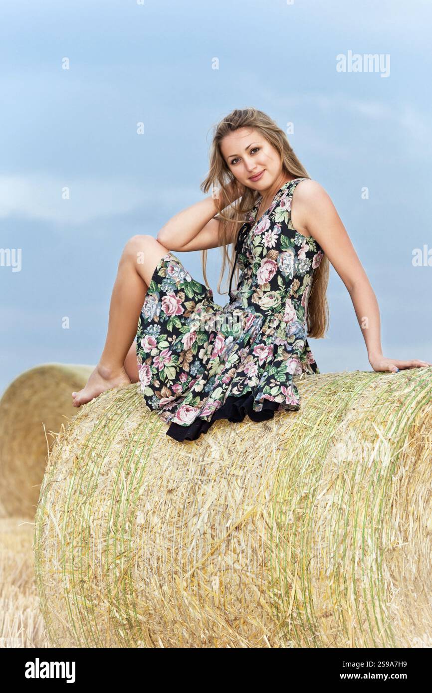 Woman having fun sitting on hay bales Stock Photo - Alamy