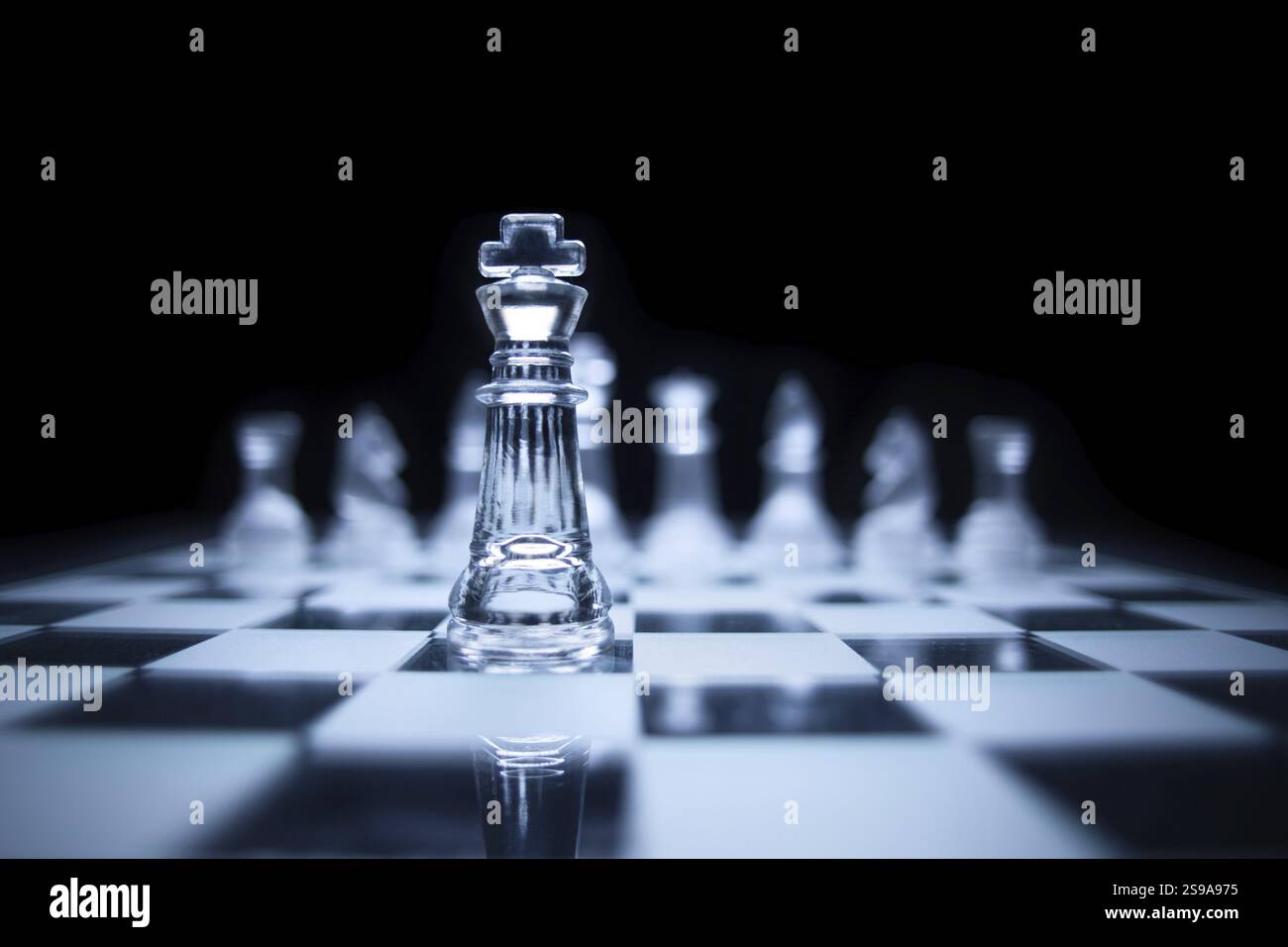 Photo of a chess king standing in front of a set of the same colour ...