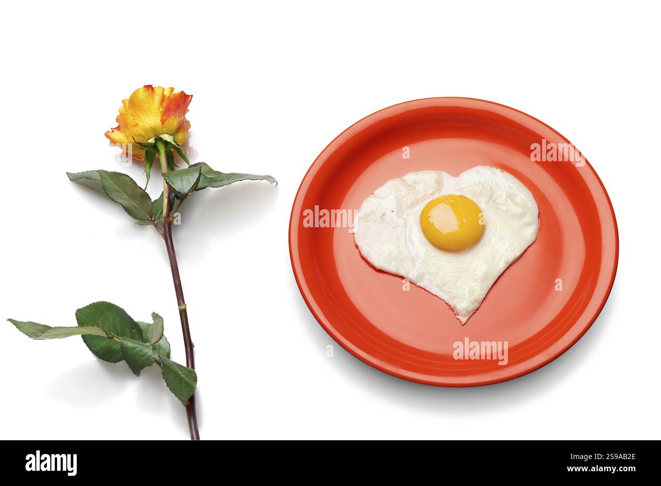 Heart-shaped egg on the red plate next to a fresh rose Stock Photo - Alamy
