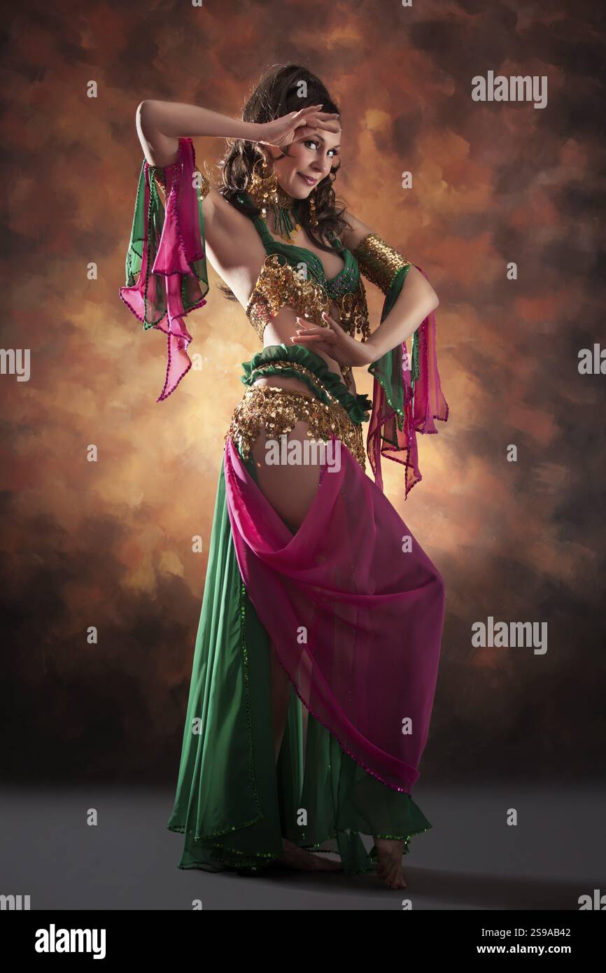 Beautiful exotic belly dancer woman a red-green costume Stock Photo - Alamy