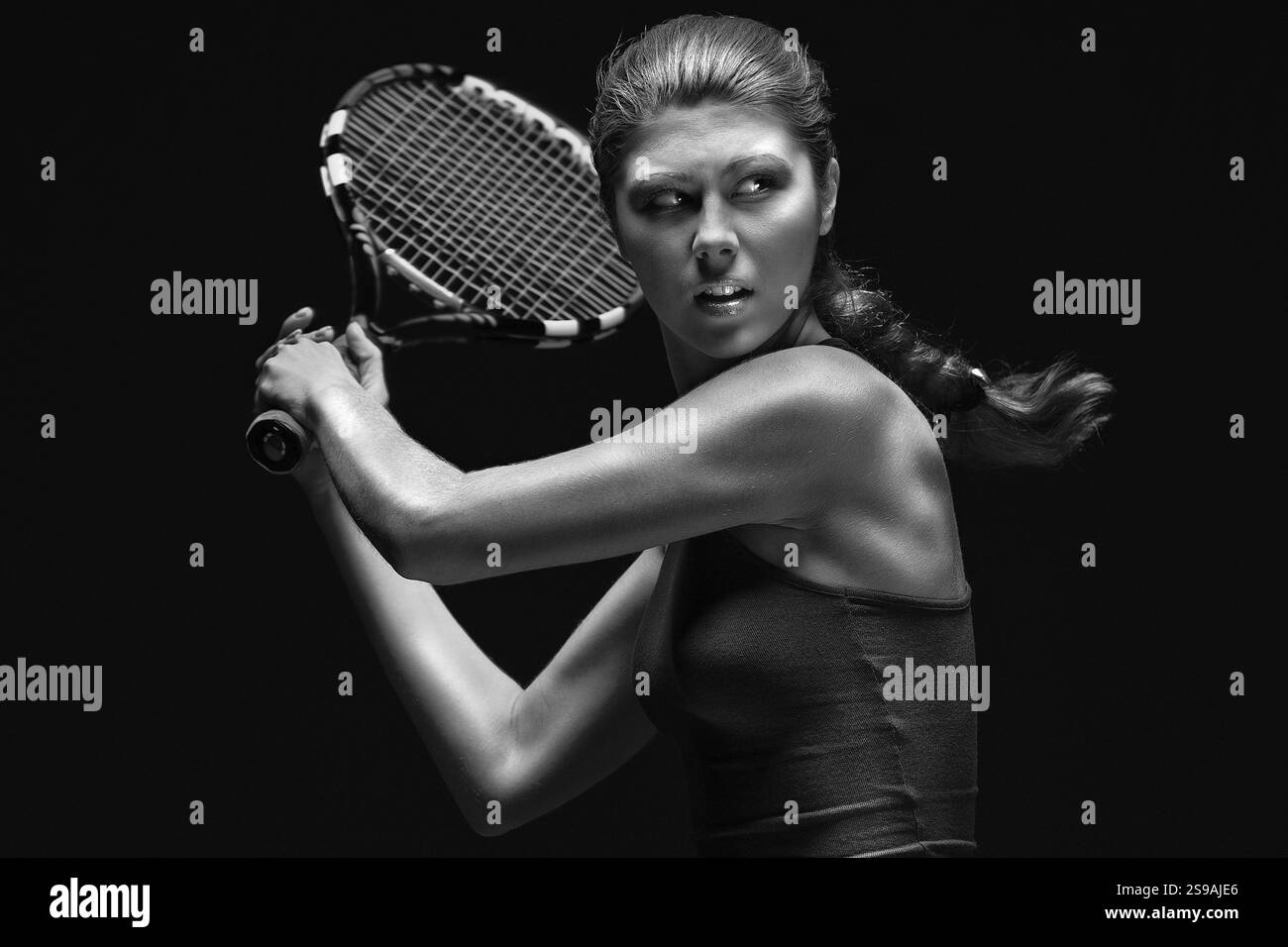 Tennis player holding racket behind her head, in front of black ...