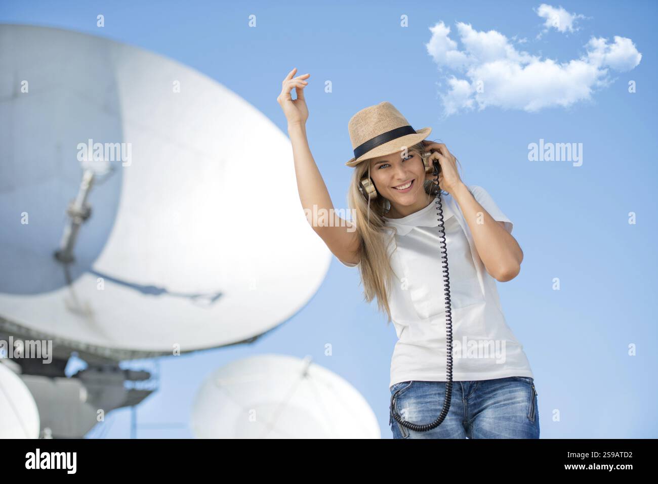 Cheerful young woman in a hat listening to music with vintage ...