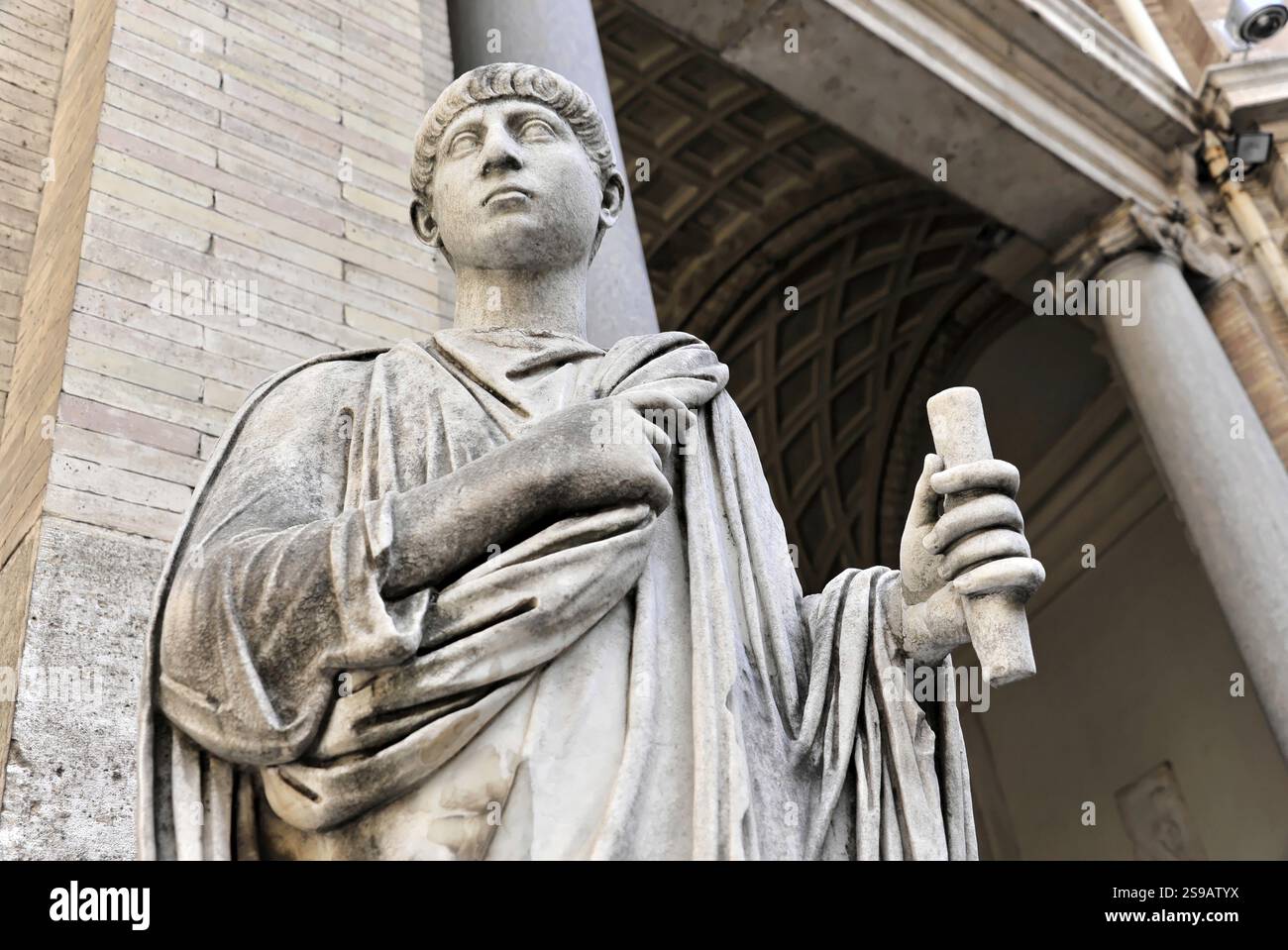 Historical marble statue of a person holding a scroll in front of a ...
