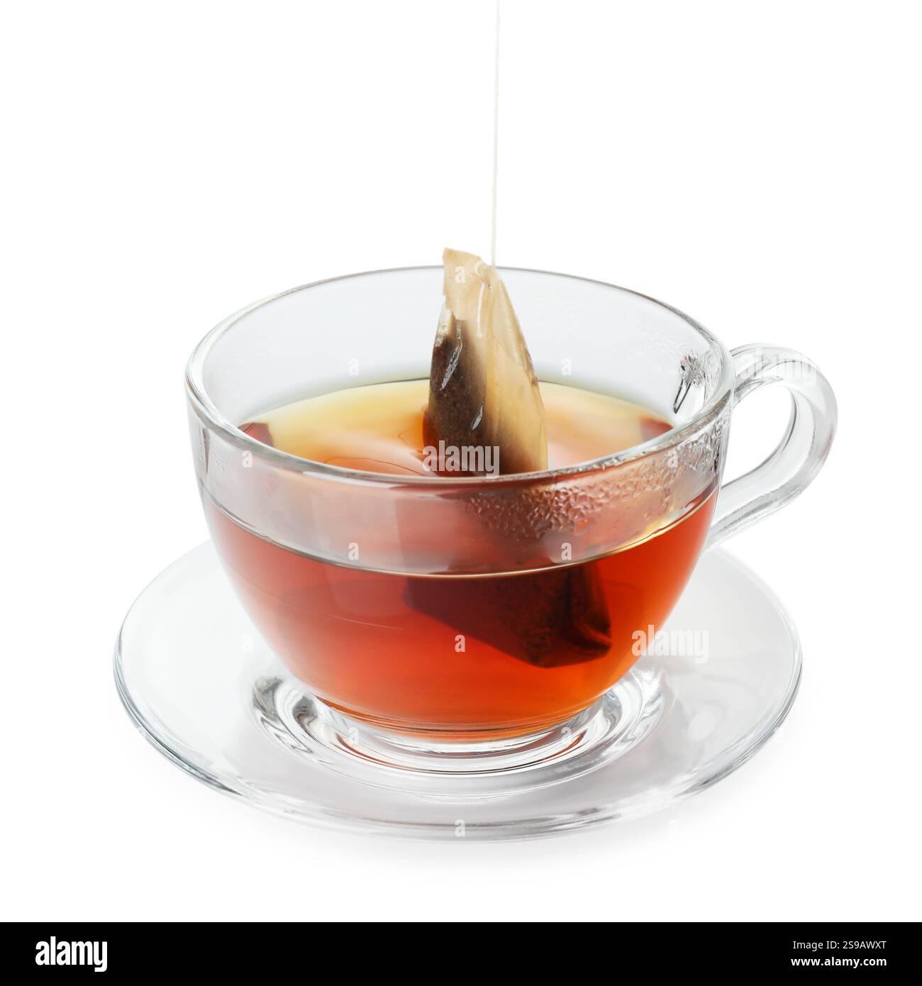 Putting tea bag into glass cup on white background Stock Photo - Alamy