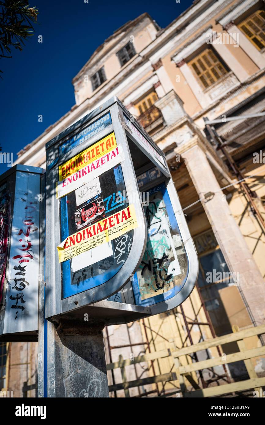 Old telephone box with graffiti and stickers on the harbour promenade ...