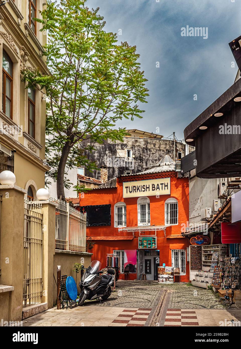 Brightly colored Turkish bath building nestled among charming shops and ...