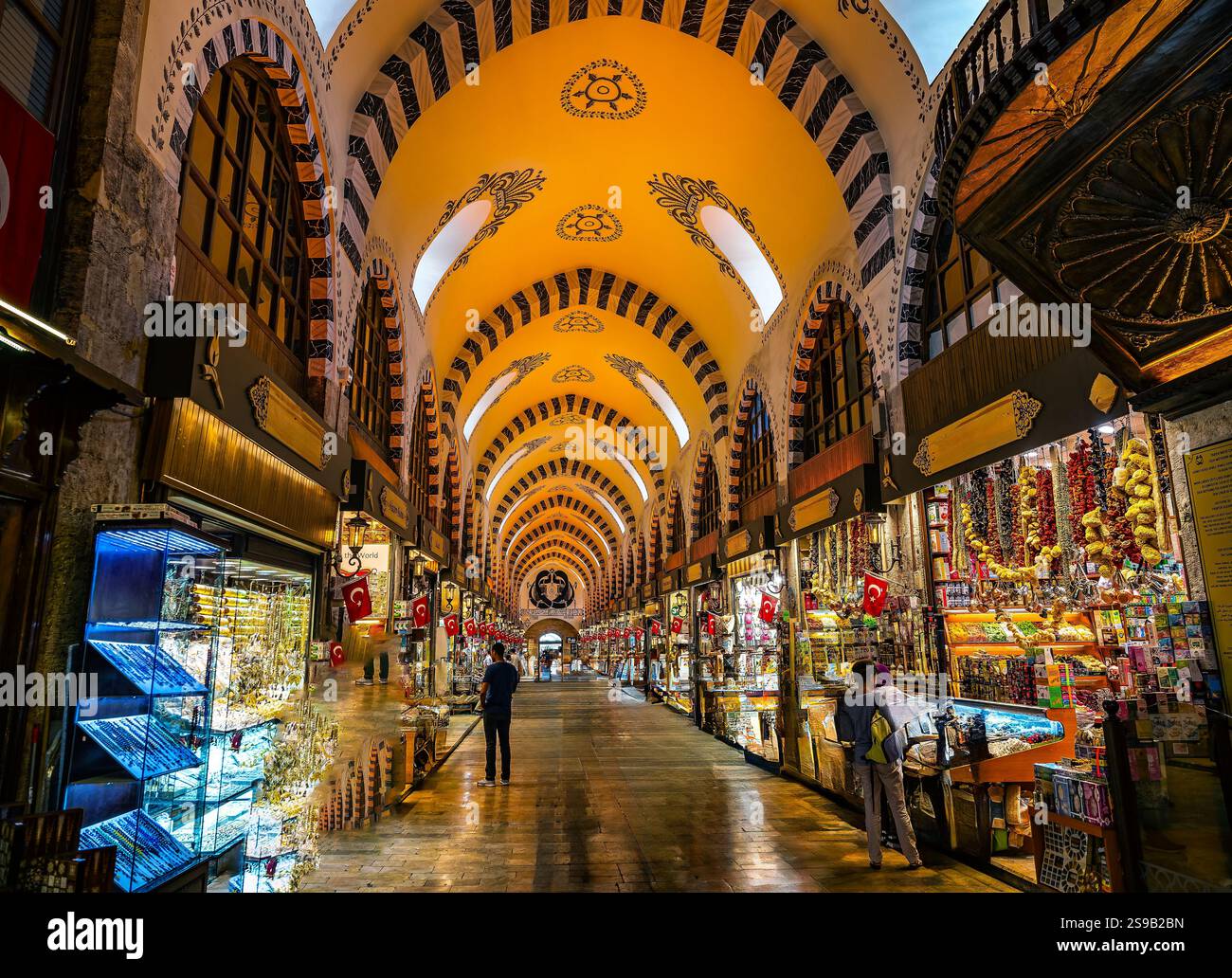 Busy indoor market with ornate yellow arched ceilings, Turkish flags ...