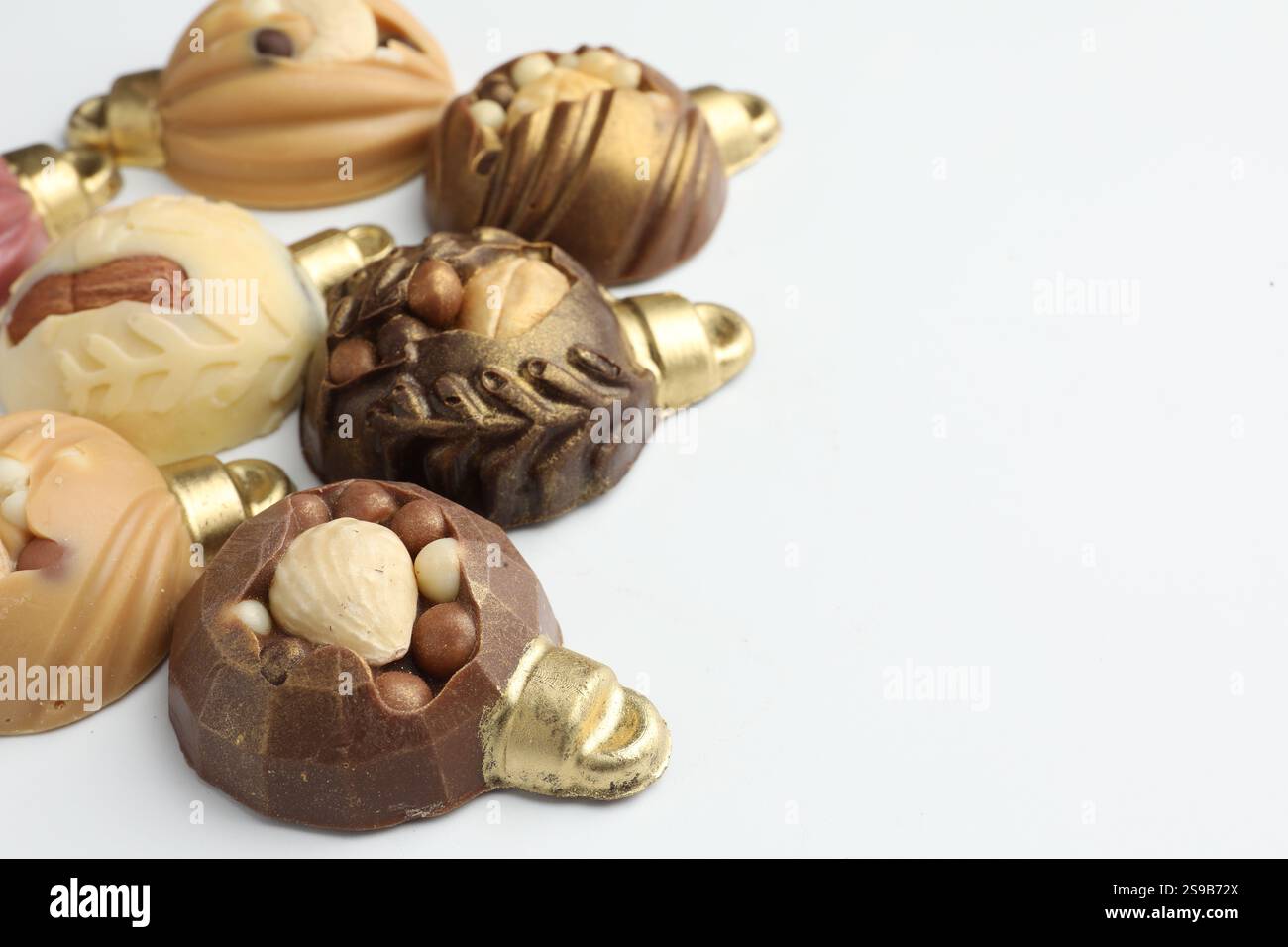 Delicious chocolate in shape of Christmas baubles on white background ...