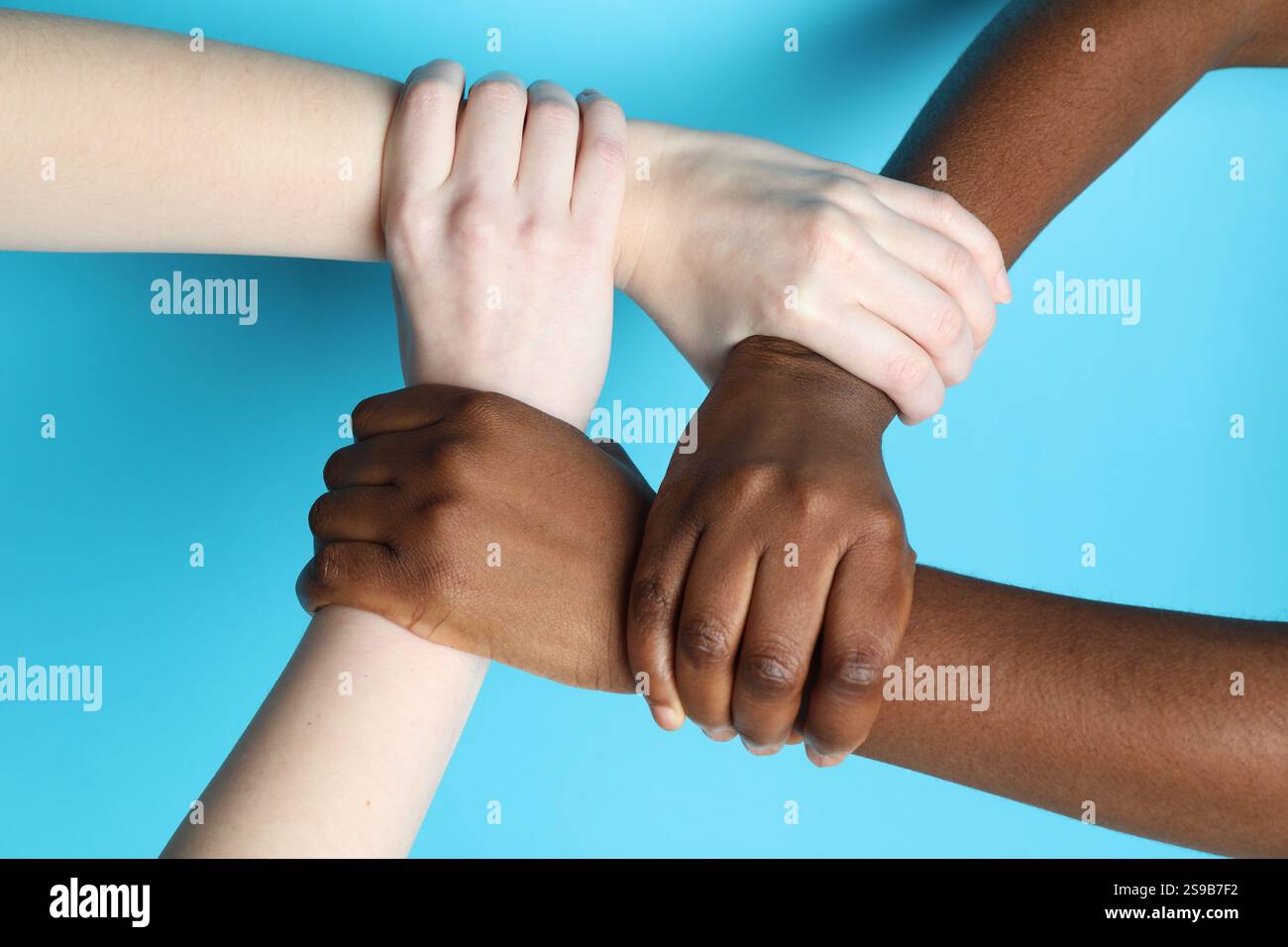 Stop racism. People of different skin colors joining hands on light ...