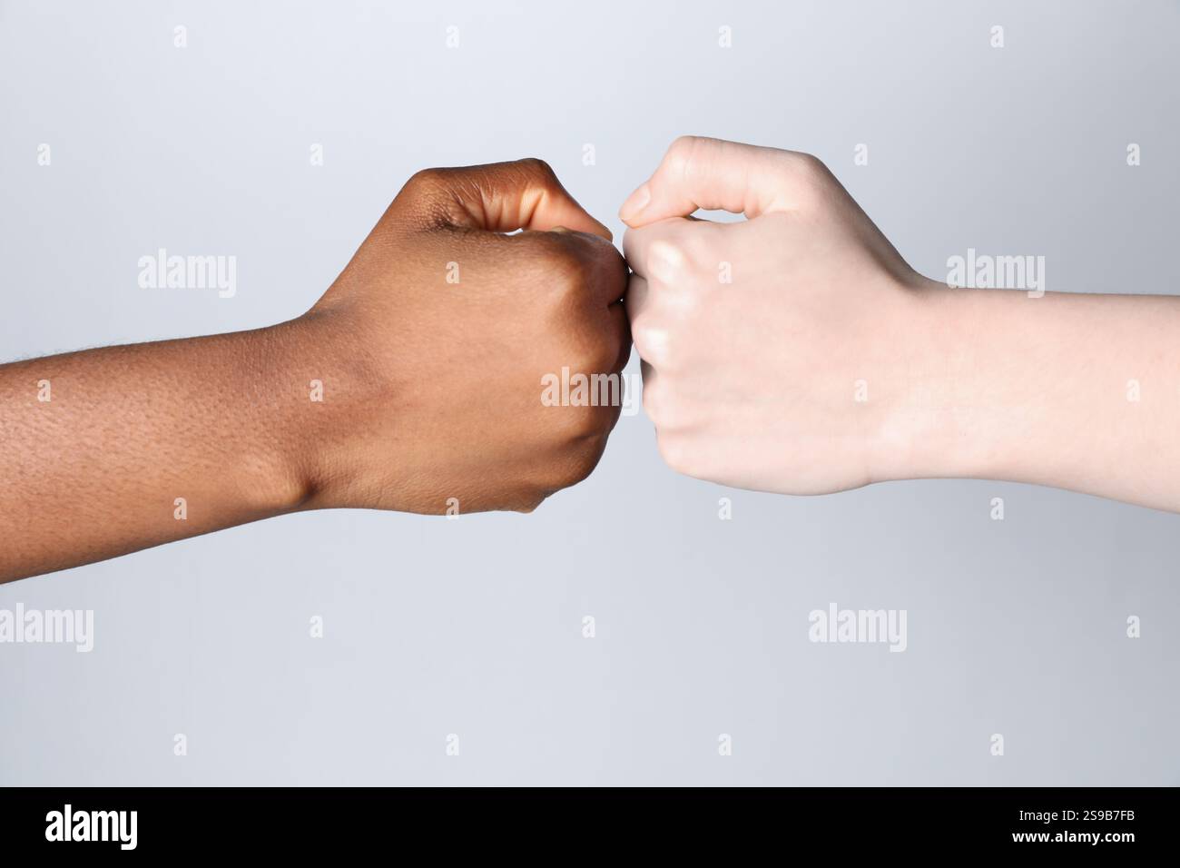Stop racism. People of different skin colors bumping fists on light ...
