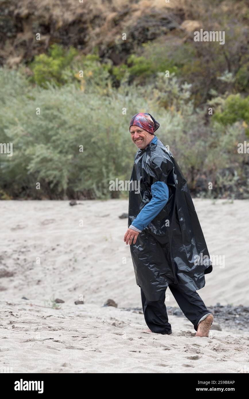 Man wearing garbage bag to protect from rain, Salmon River, Idaho Stock ...