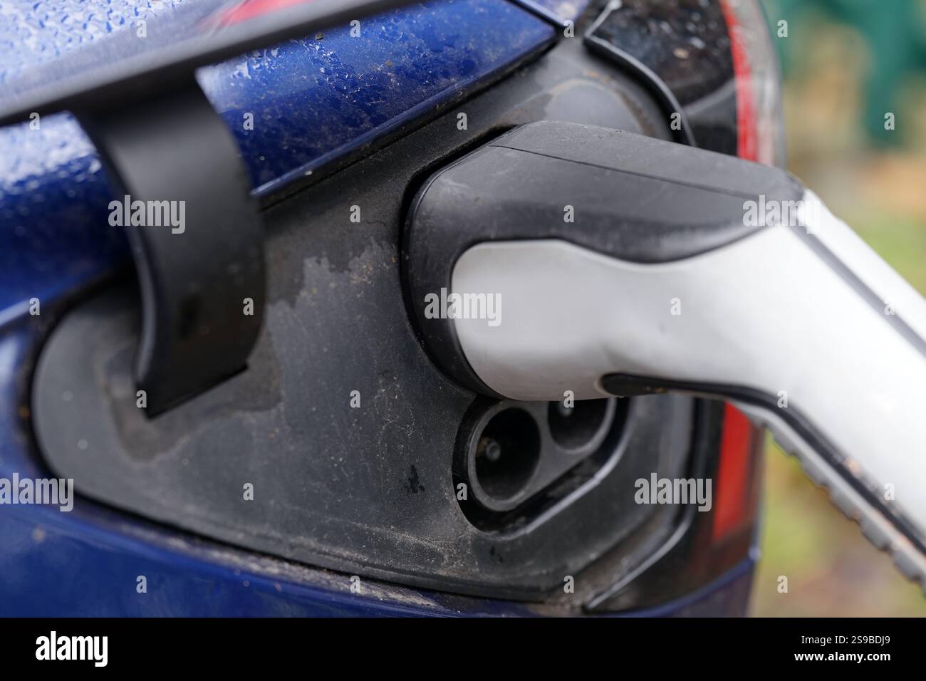 A Type 2 plug connected to an electric car. Type 2 plug offers space ...