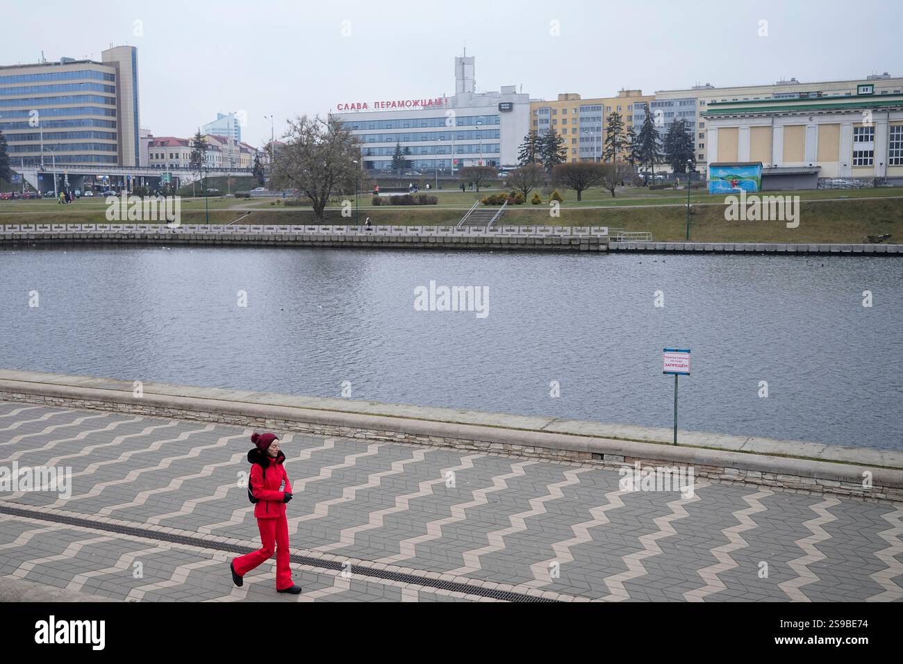 A woman walks by the embankment of Svislach river in Minsk, Belarus ...