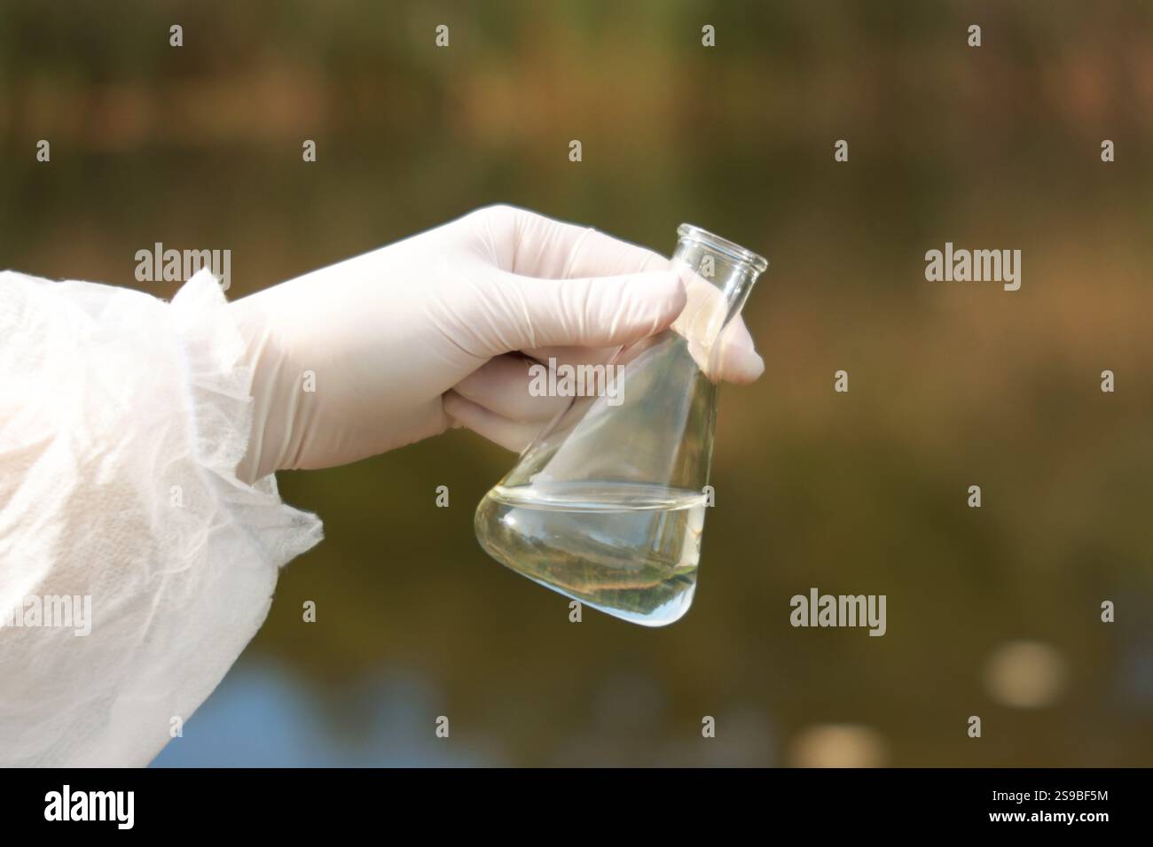 Examination of water quality. Researcher holding flask with sample ...