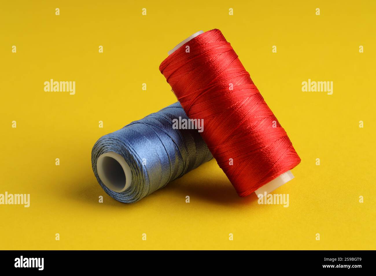 Different spools of sewing threads on yellow background, closeup Stock ...