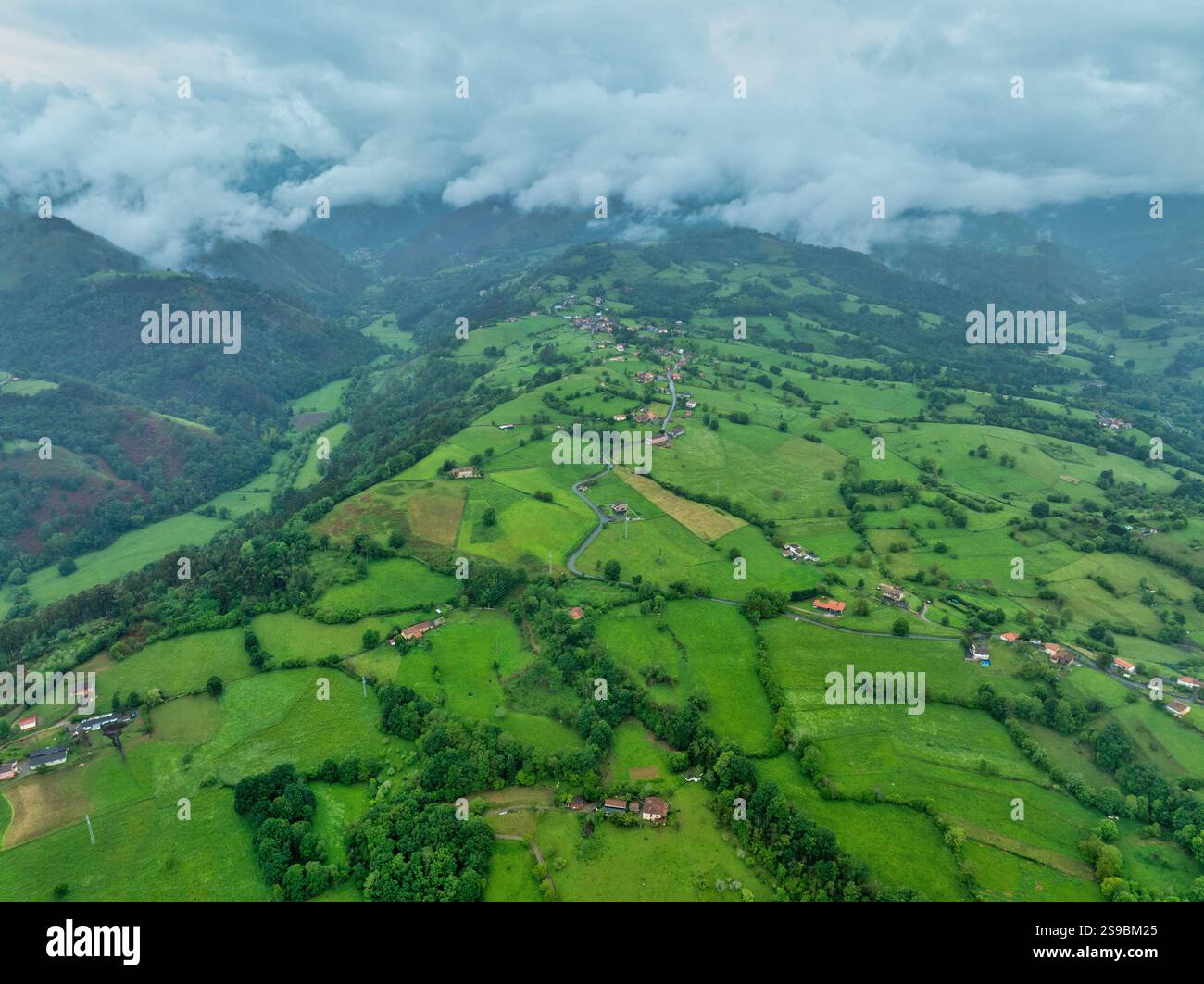 Aerial view of misty village surrounded by mountains and forest ...