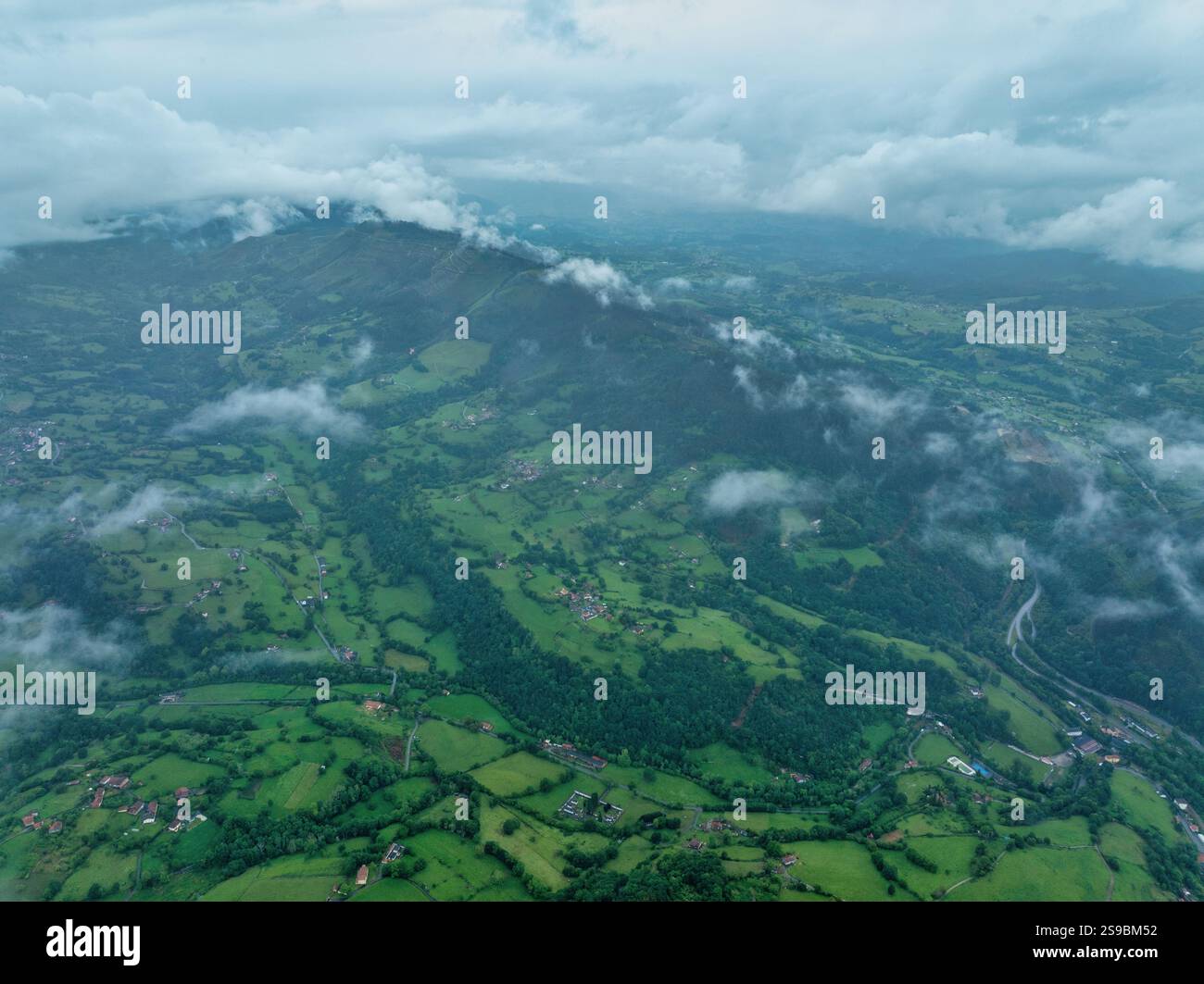 Aerial view of misty village surrounded by mountains and forest ...