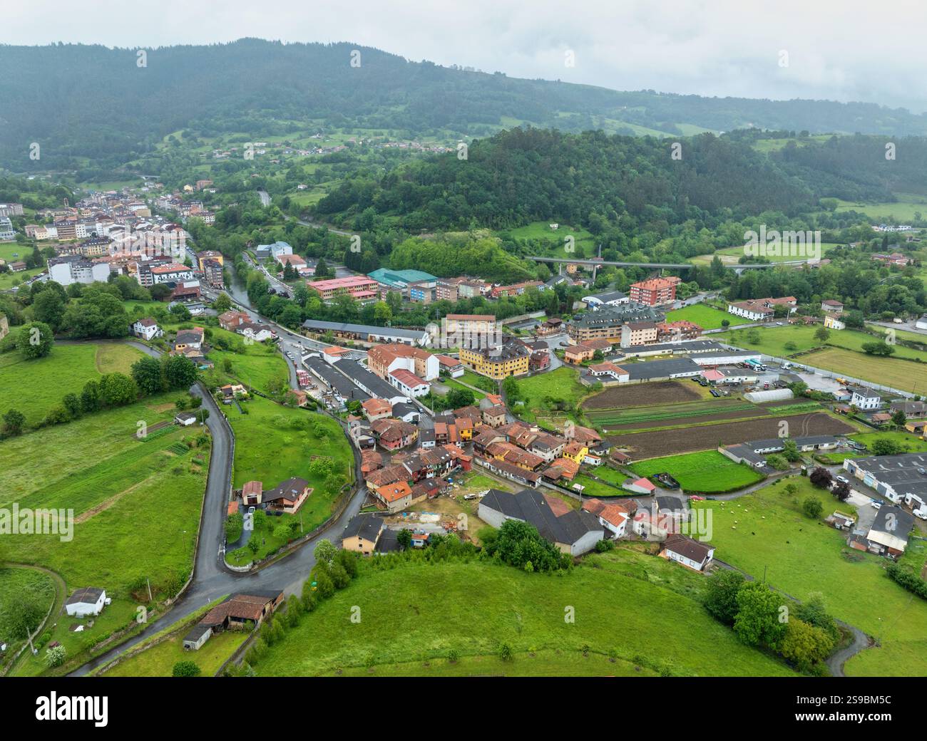 Aerial view of misty village surrounded by mountains and forest ...