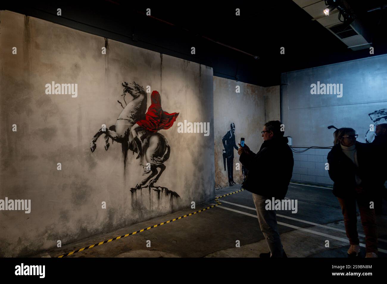 Several people walk through the permanent exhibition of Banksy's works ...